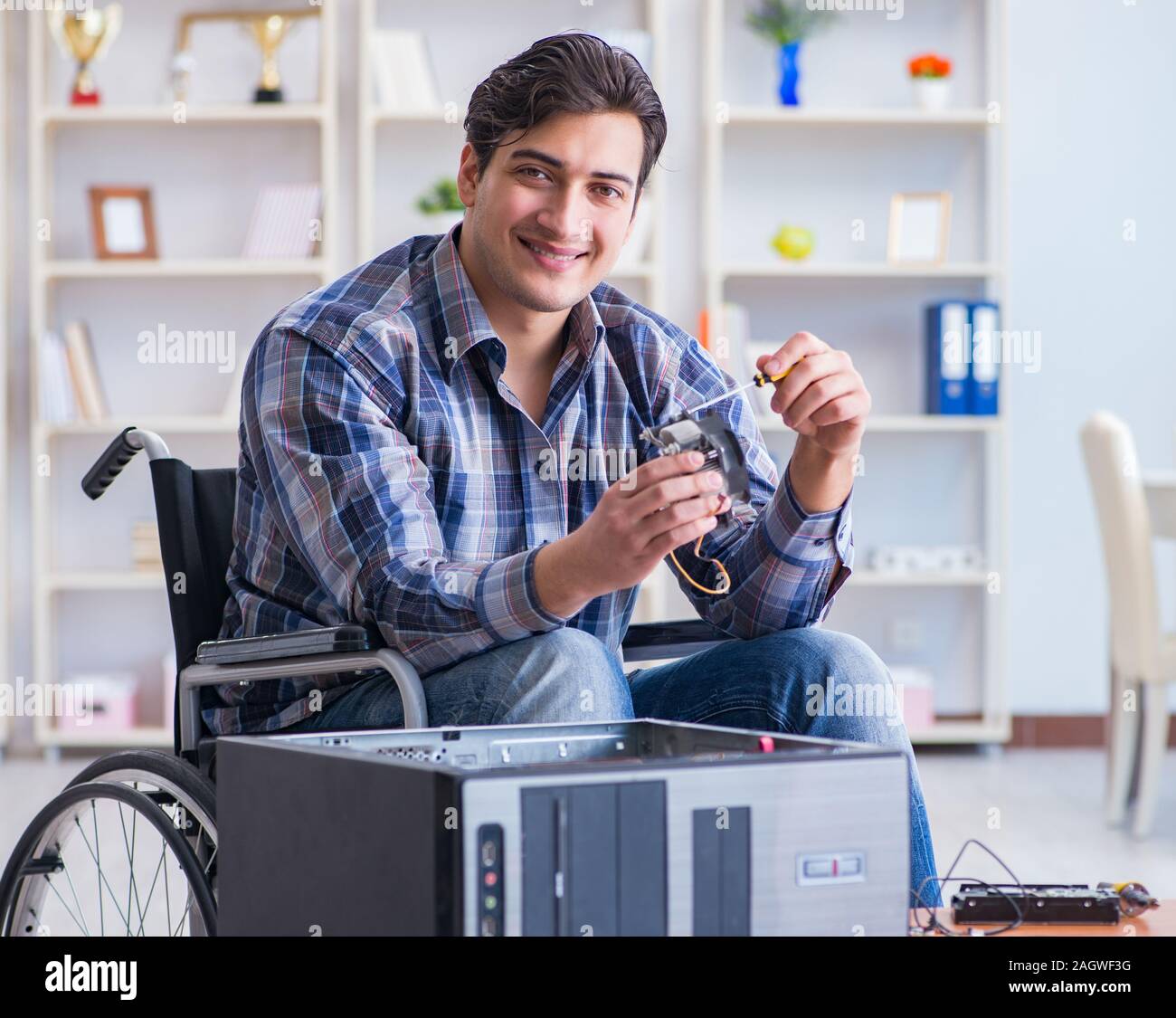 The computer repairman on wheelchair working Stock Photo - Alamy