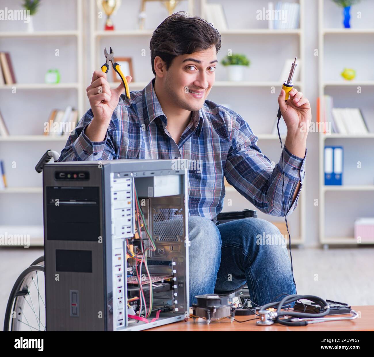 The computer repairman on wheelchair working Stock Photo - Alamy