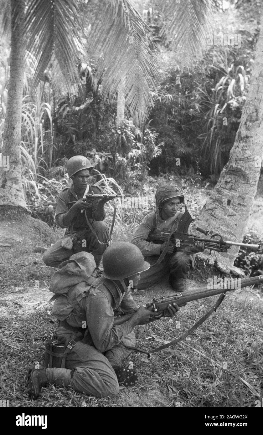 Three KNIL soldiers with different weapons at hand (stengun, bren ...