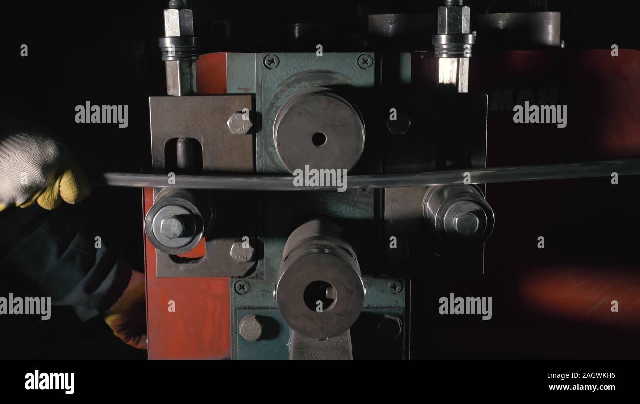 Forge workshop on table. Worker bends the metal rod on the wrought iron ...