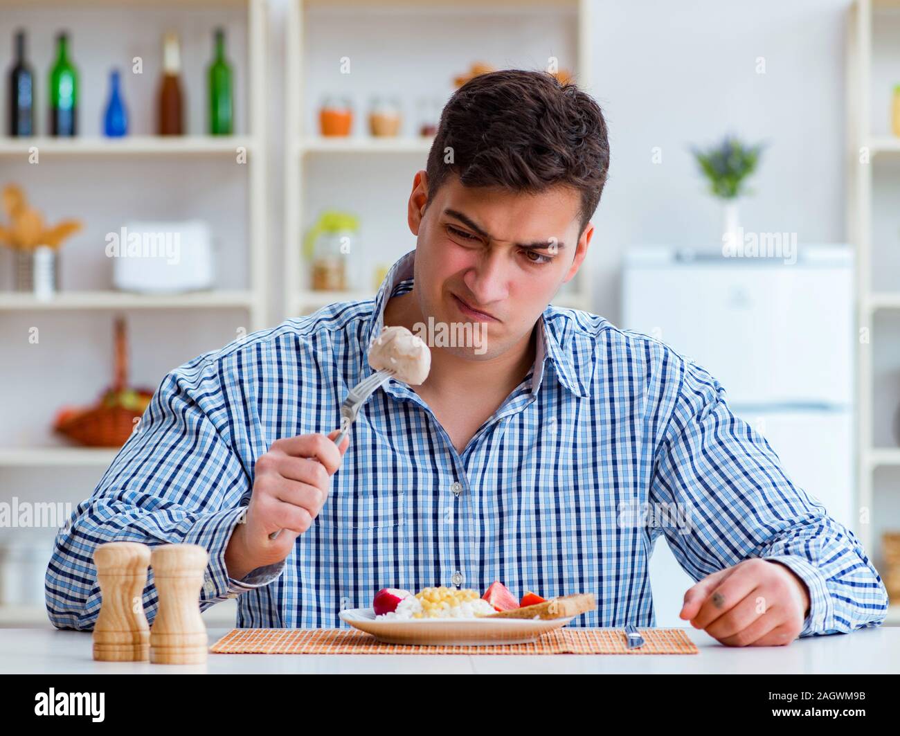 The man eating tasteless food at home for lunch Stock Photo - Alamy