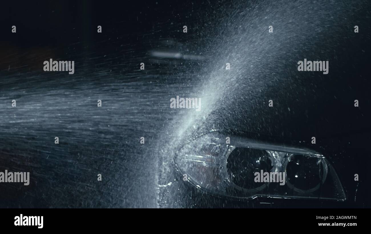 Car headlight wash. Washing modern vehicle body by high pressure jet ...