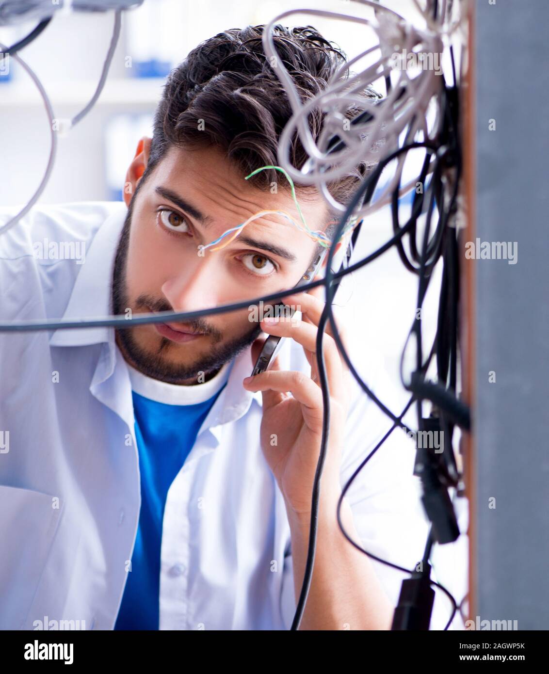 The electrician trying to untangle wires in repair concept Stock Photo ...