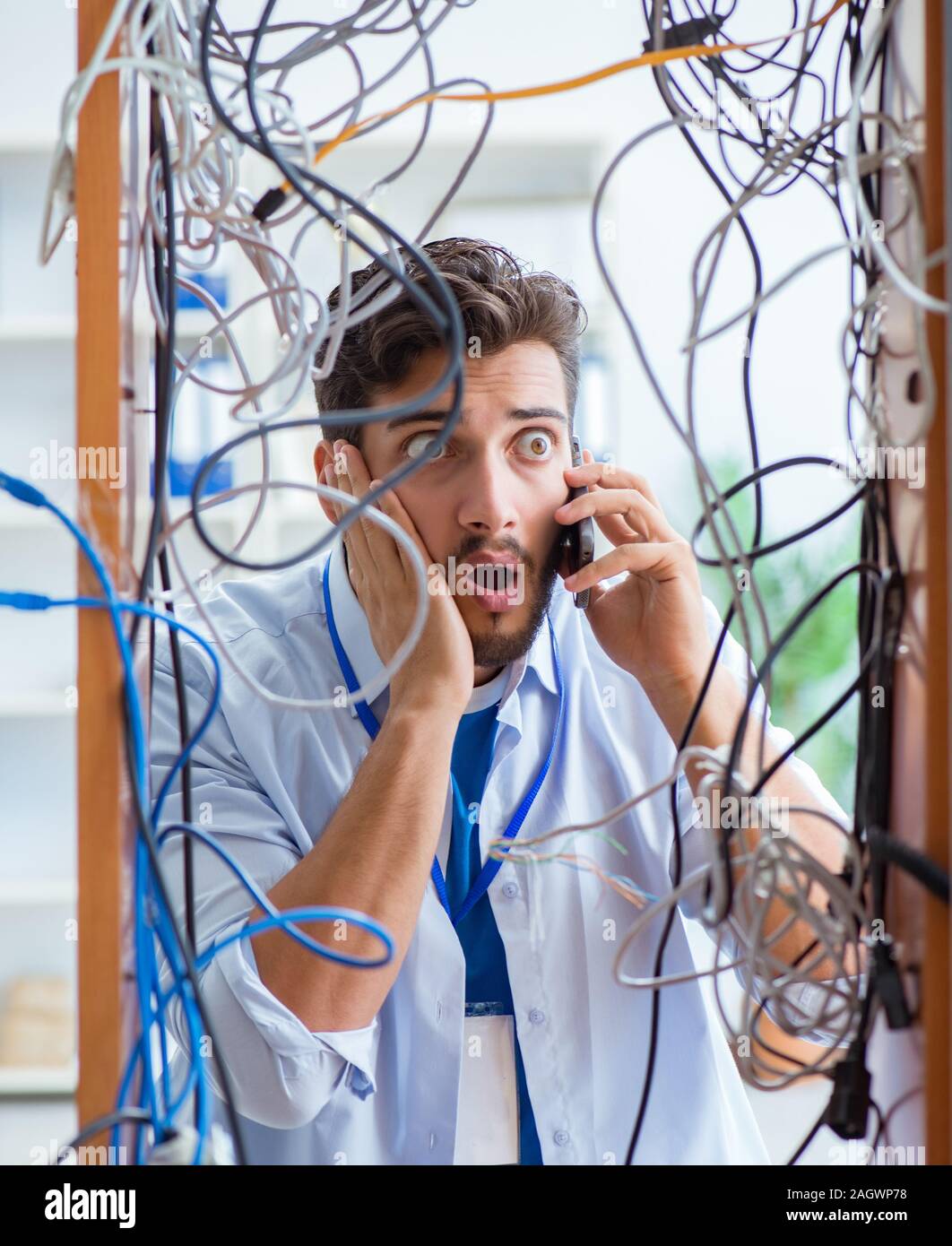 The electrician trying to untangle wires in repair concept Stock Photo ...