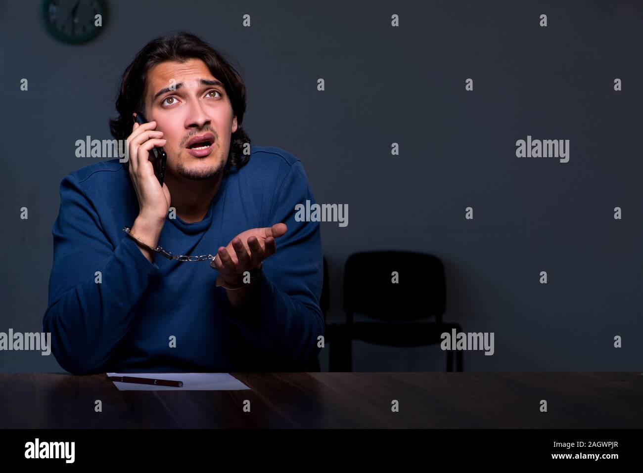 The young convict man sitting in dark room Stock Photo - Alamy
