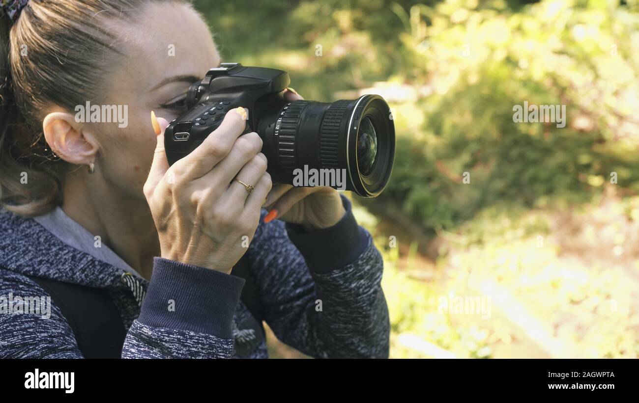 Traveler photographing scenic view in forest. One caucasian woman ...