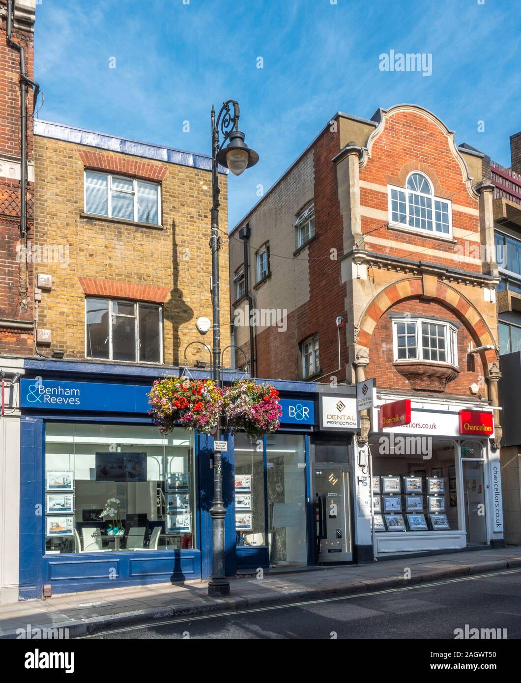 Local businesses, with no people around and sunlit shop fronts, in ...