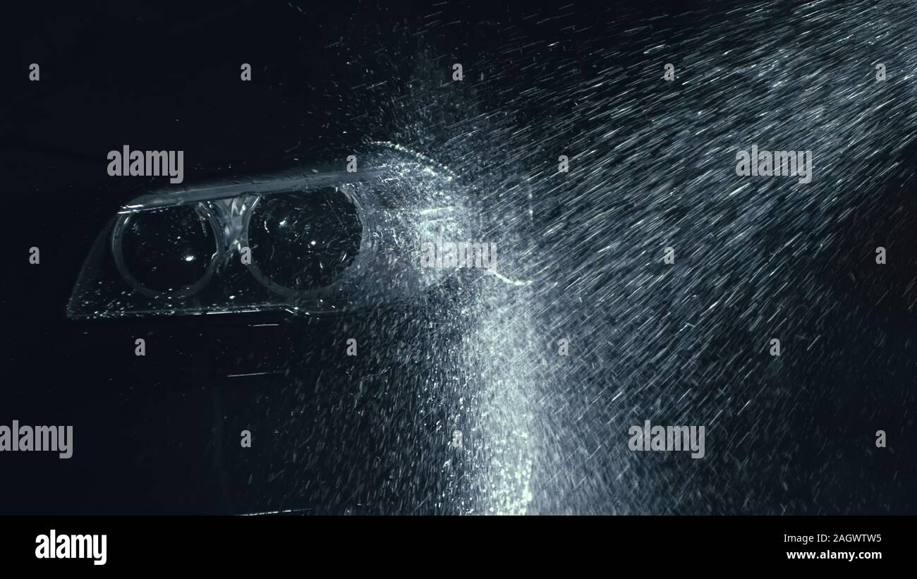 Car headlight wash. Washing modern vehicle body by high pressure jet ...