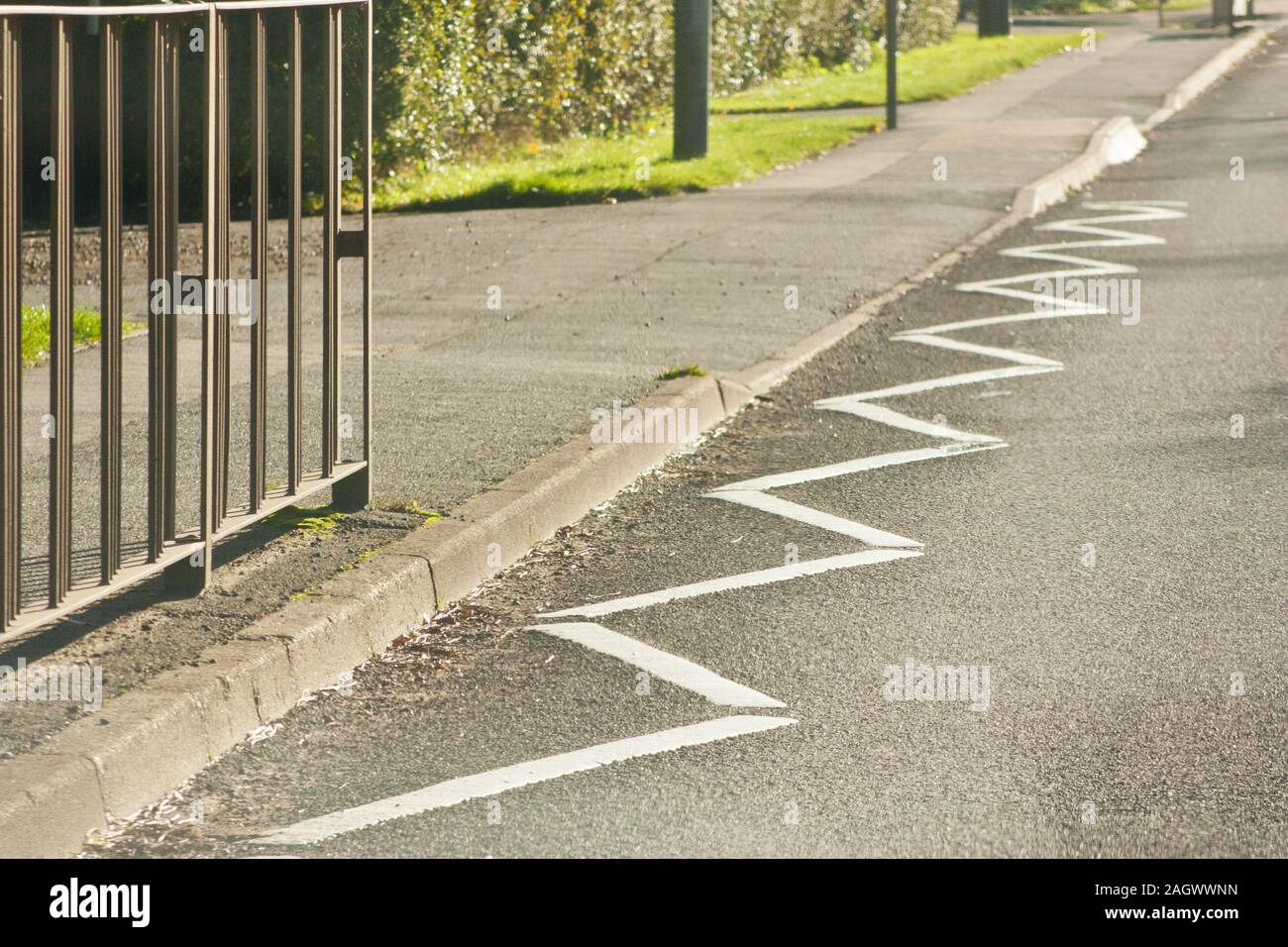 A white zig-zag no stopping line at the side of a UK road to indicate ...