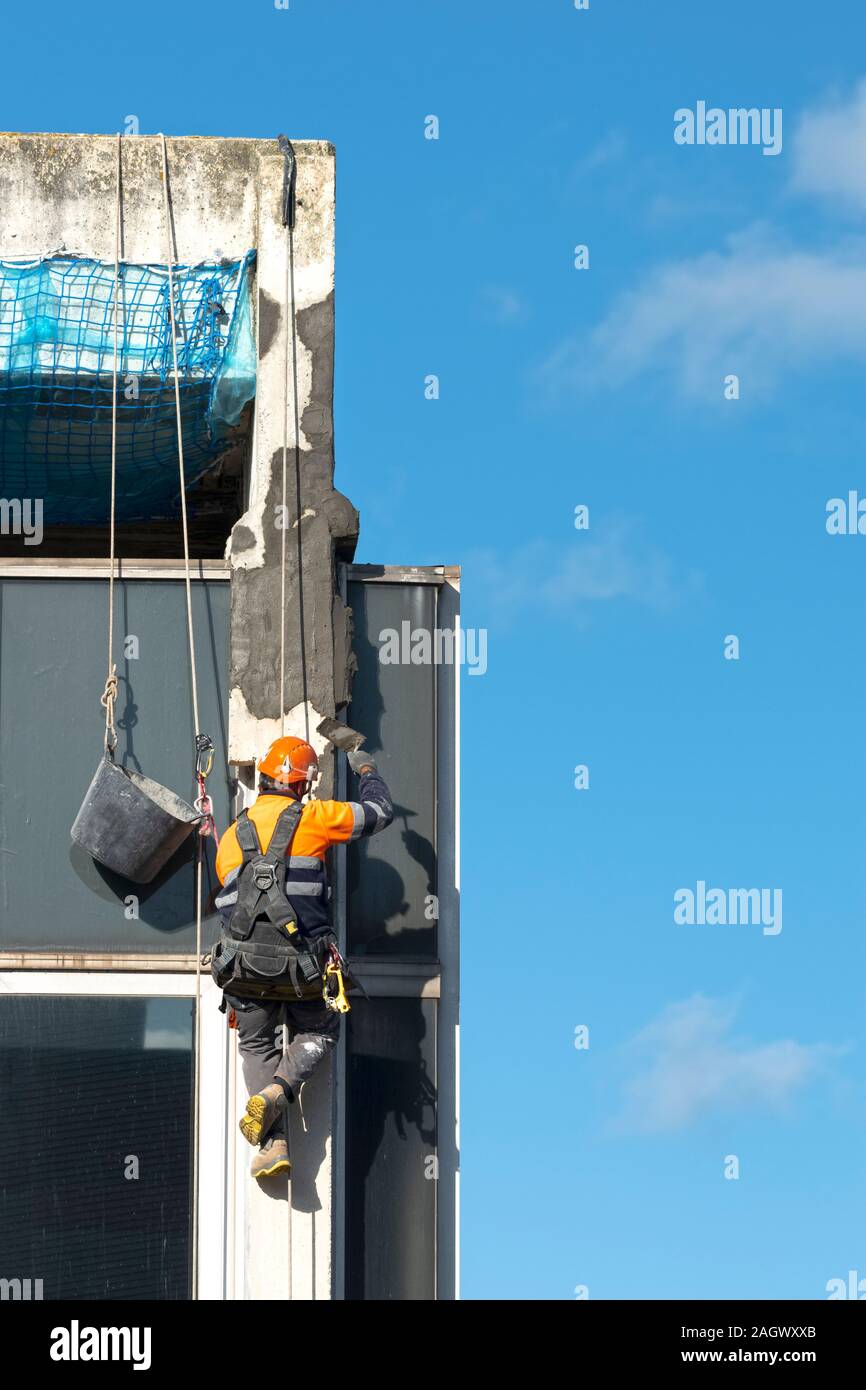 worker at height fixing a facade with cement Stock Photo - Alamy