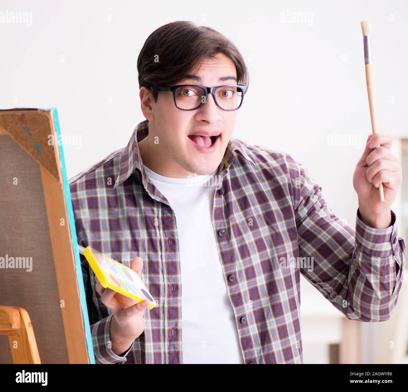 The young male artist drawing pictures in bright studio Stock Photo - Alamy