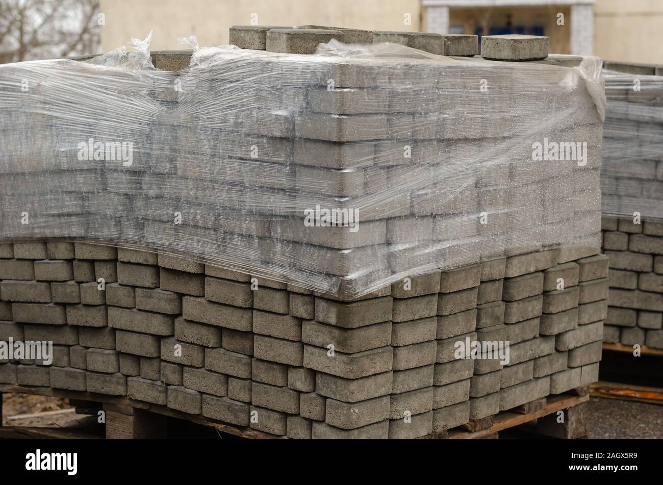 Pallet of new paving slabs with raindrops outdoors. Side view of a gray ...