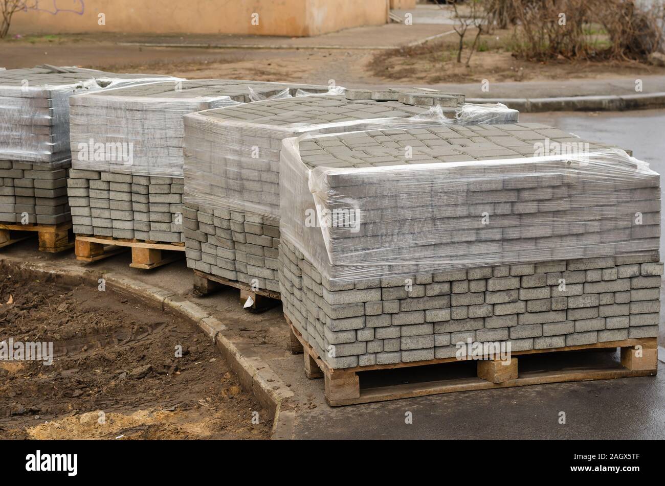 Four pallets with new paving tiles. Pallets with gray paving slabs wet ...
