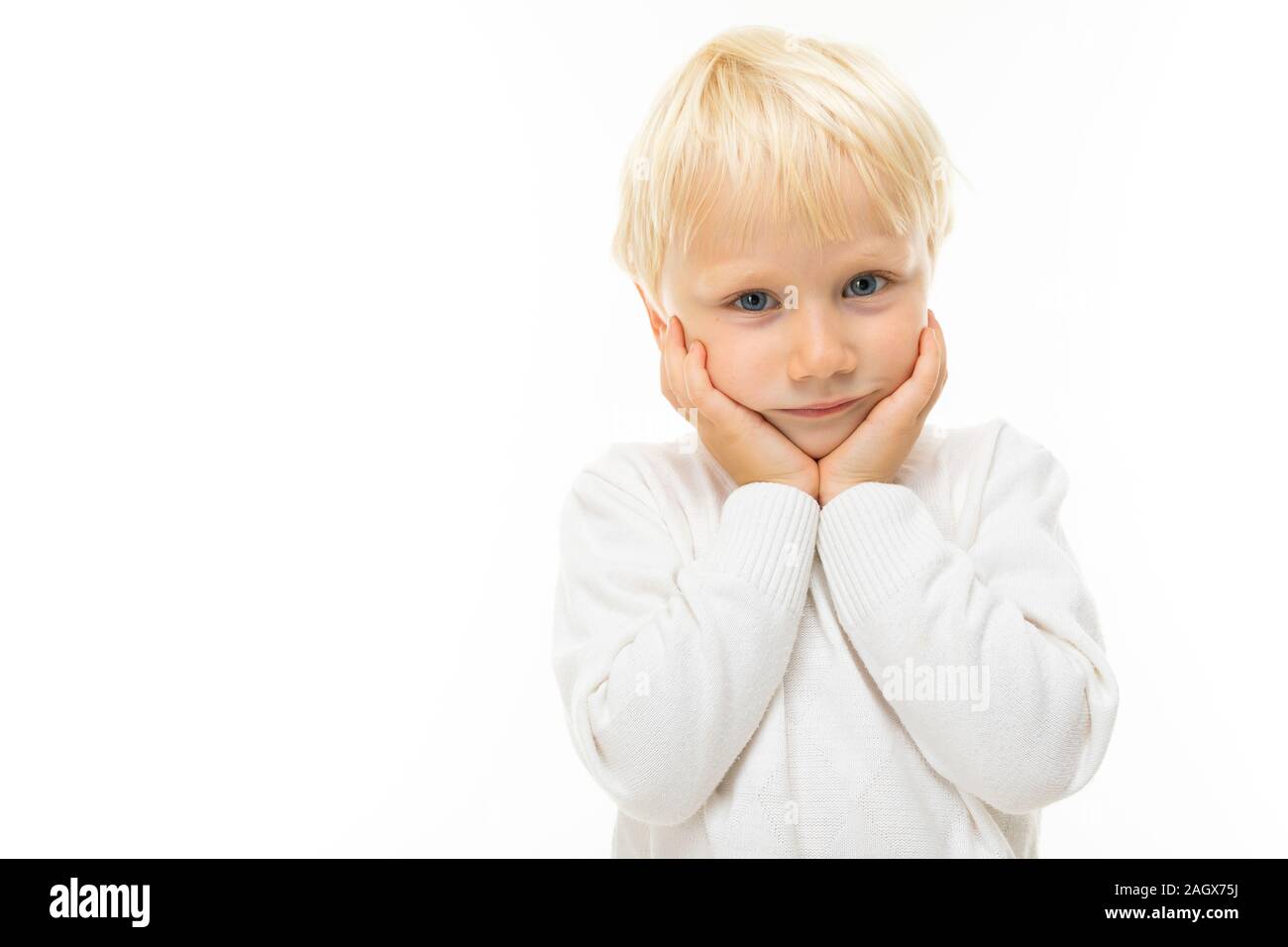 portrait of a charming modest blond boy in a white t-shirt on a white ...