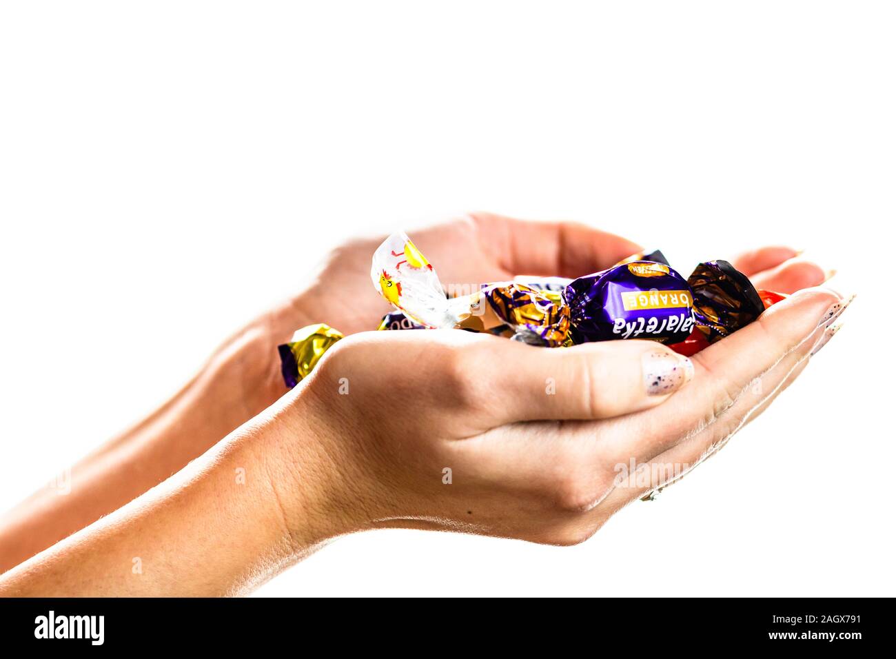 Woman hands holding Christmas candies in her hands isolated on white ...