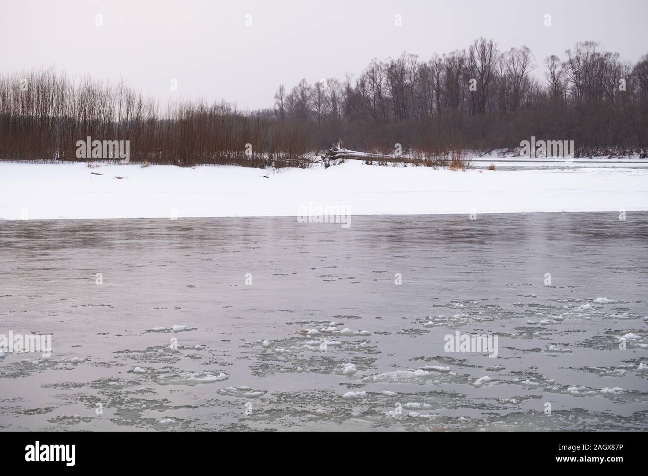 Mountain Russian river in winter. Snow on the shore. Rapid flow of ice ...