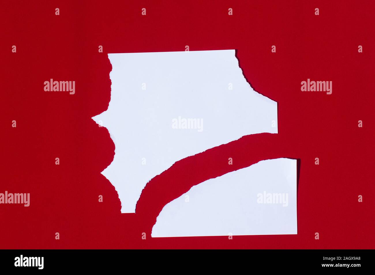 White paper broken into pieces on a red background Stock Photo - Alamy