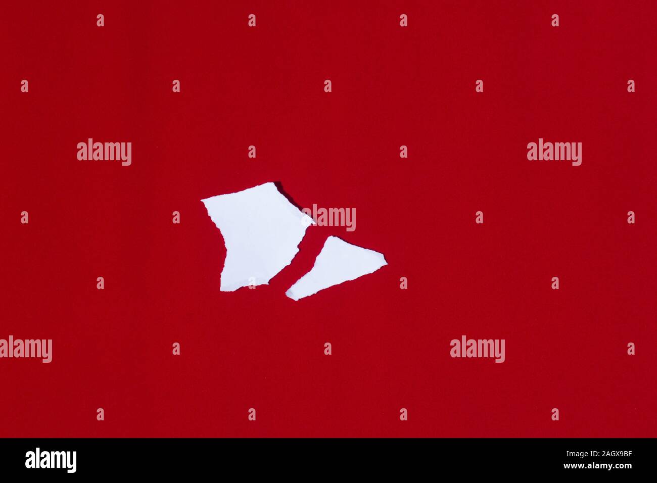 White paper broken into pieces on a red background Stock Photo - Alamy