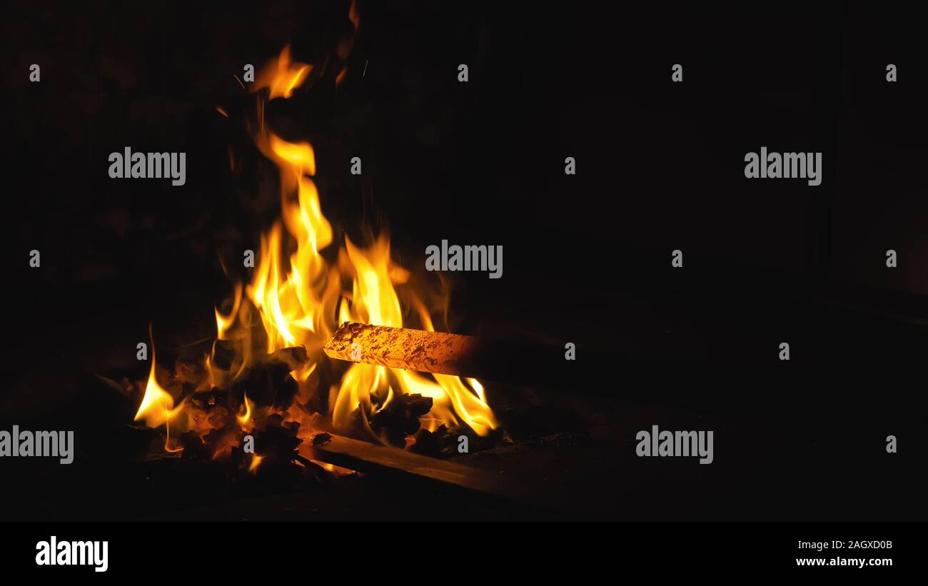 Forge fire in furnace. Blacksmith tempers a steel product in a stove ...