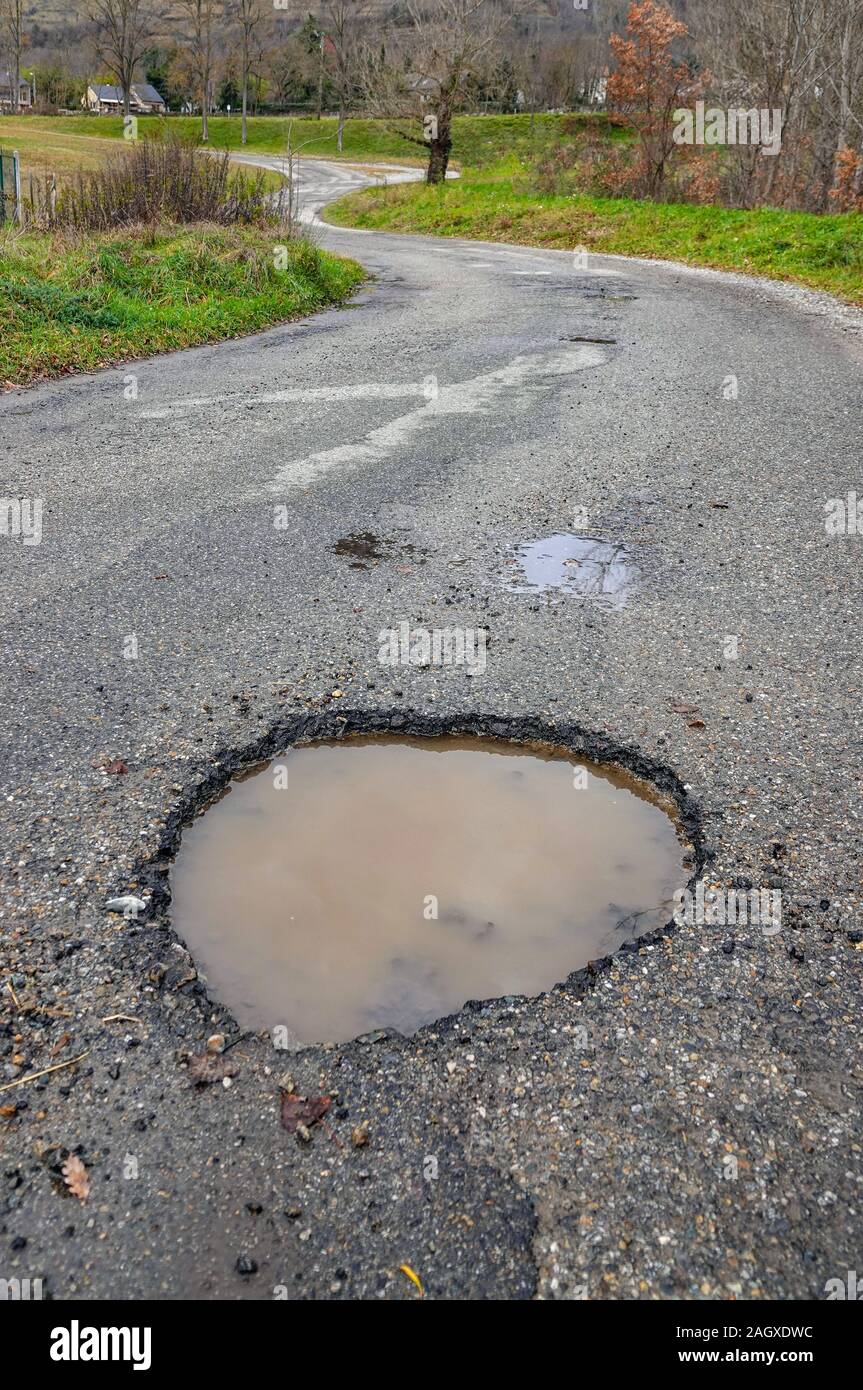 Large water-filed pothole in centre of minor country road, France Stock ...
