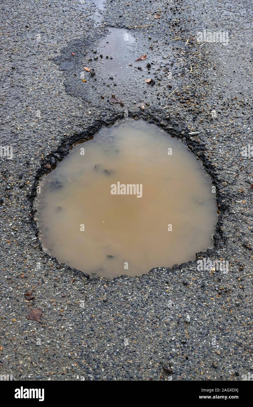 Large water-filed pothole in centre of minor country road, France Stock ...