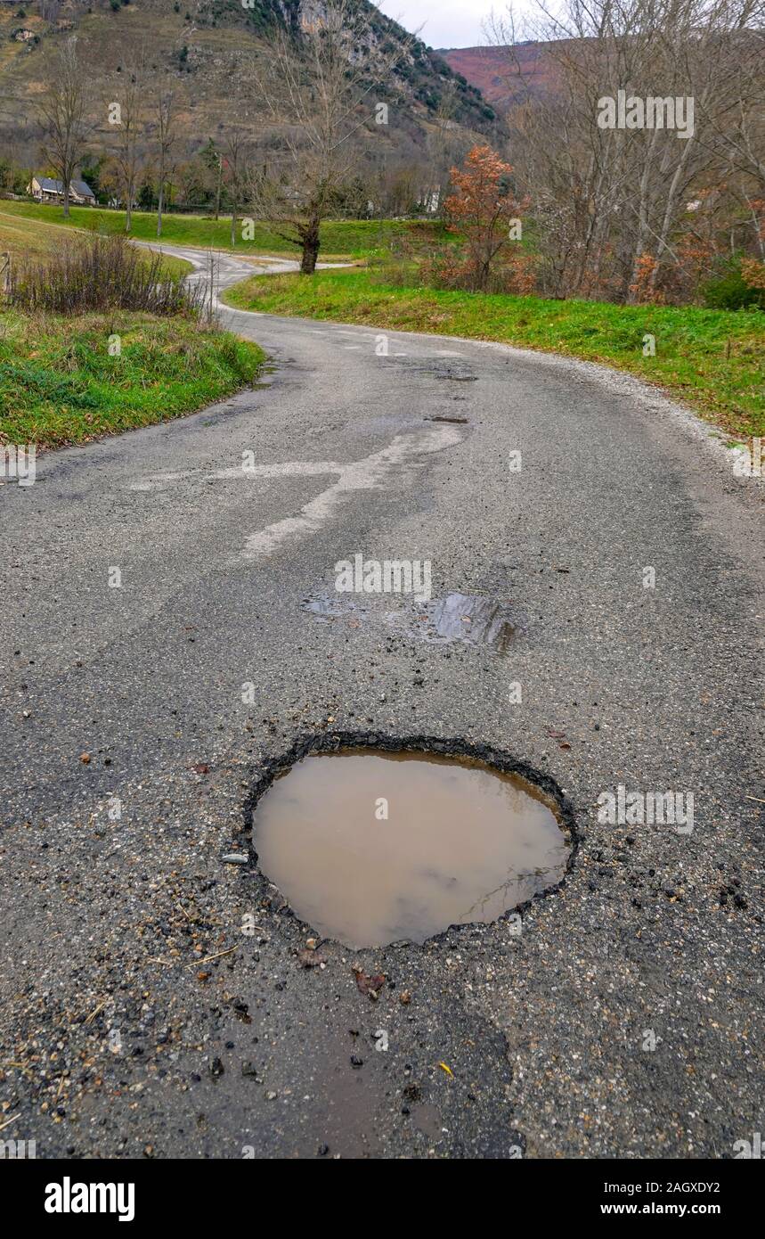 Large water-filed pothole in centre of minor country road, France Stock ...