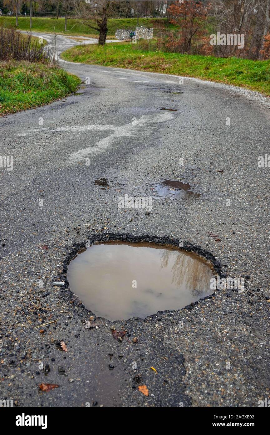 Large water-filed pothole in centre of minor country road, France Stock ...