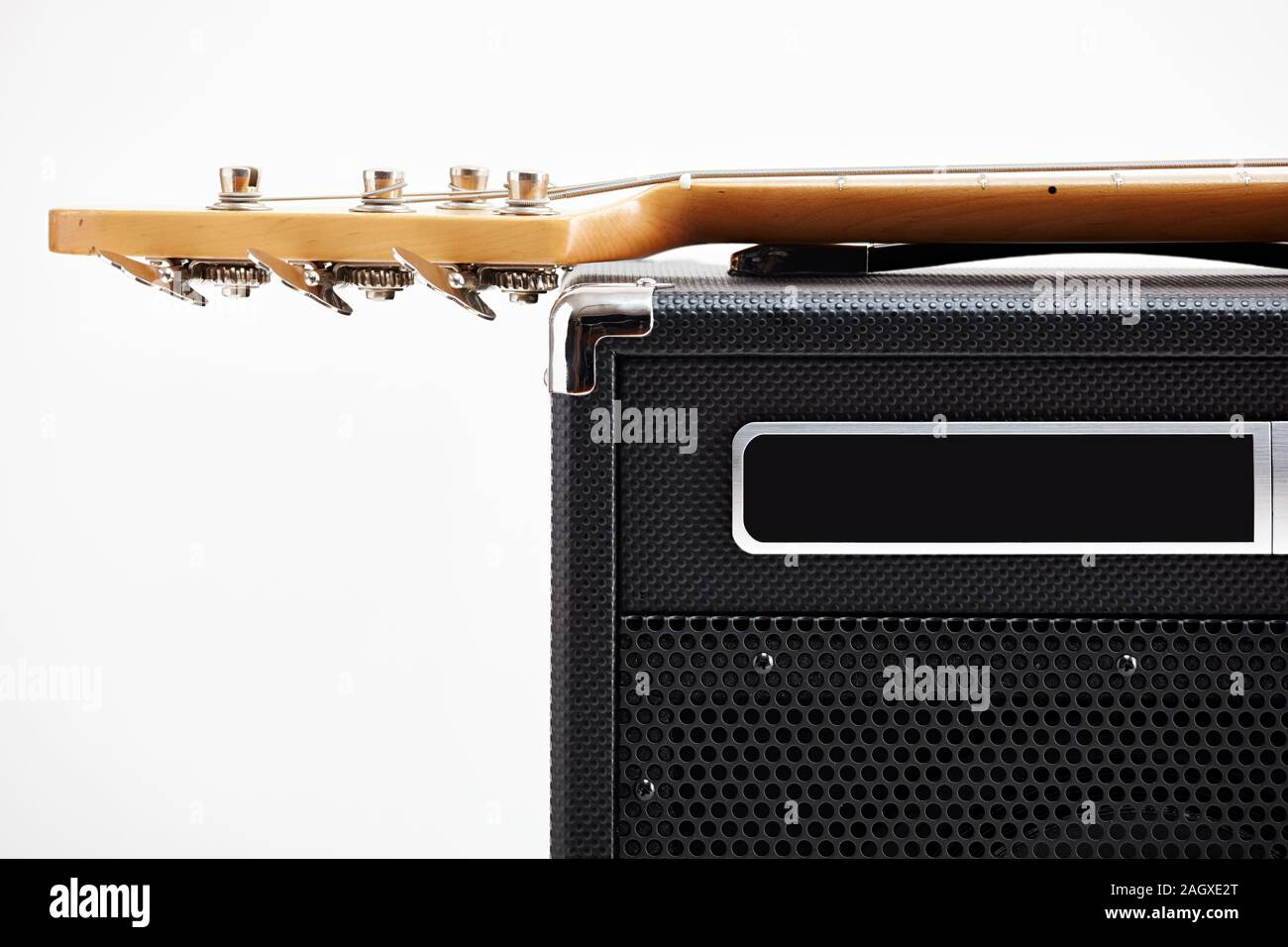 Electric bass guitar on black amplifier against white background with ...