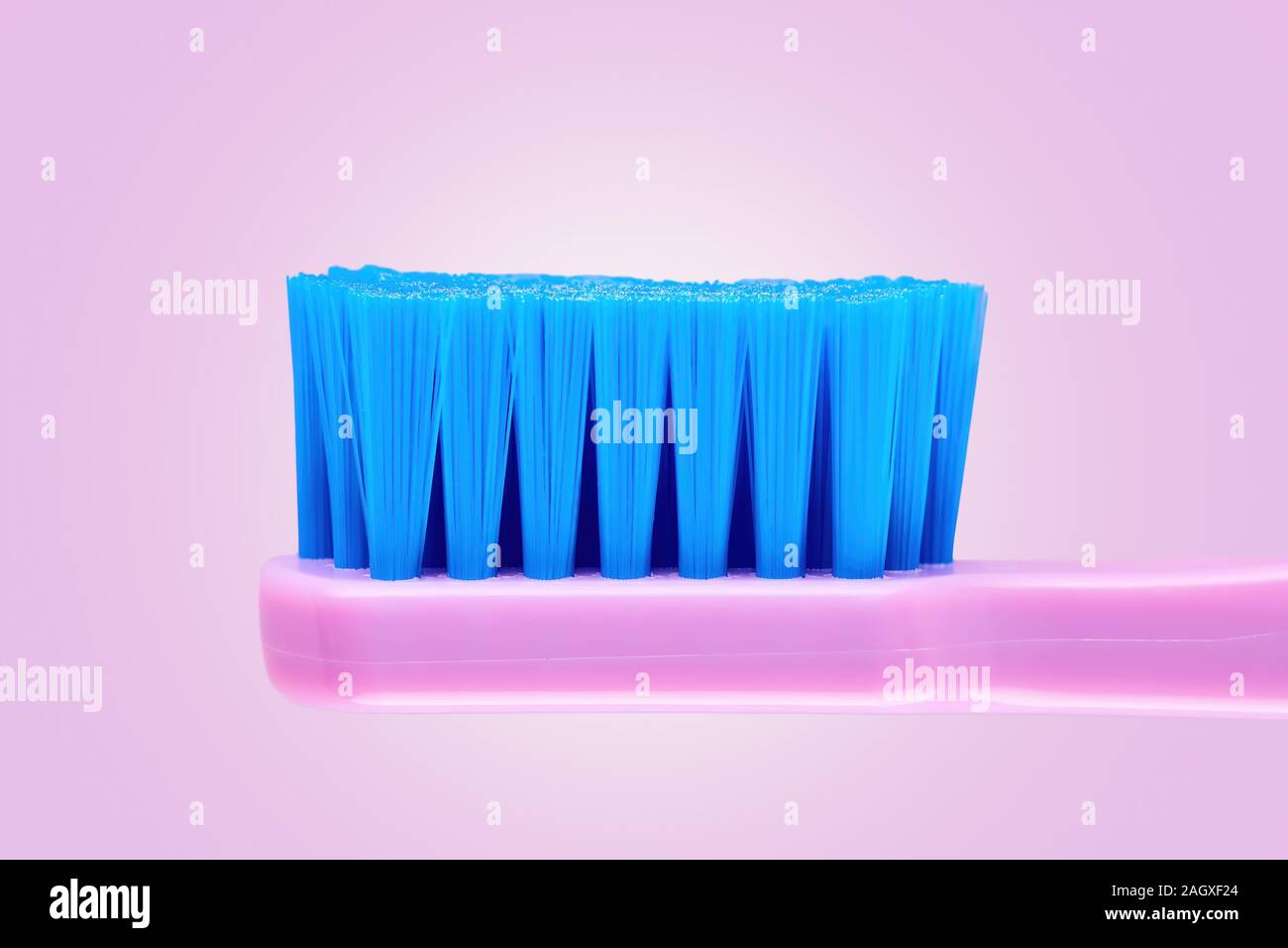 Close up side view of a new purple toothbrush on purple background ...