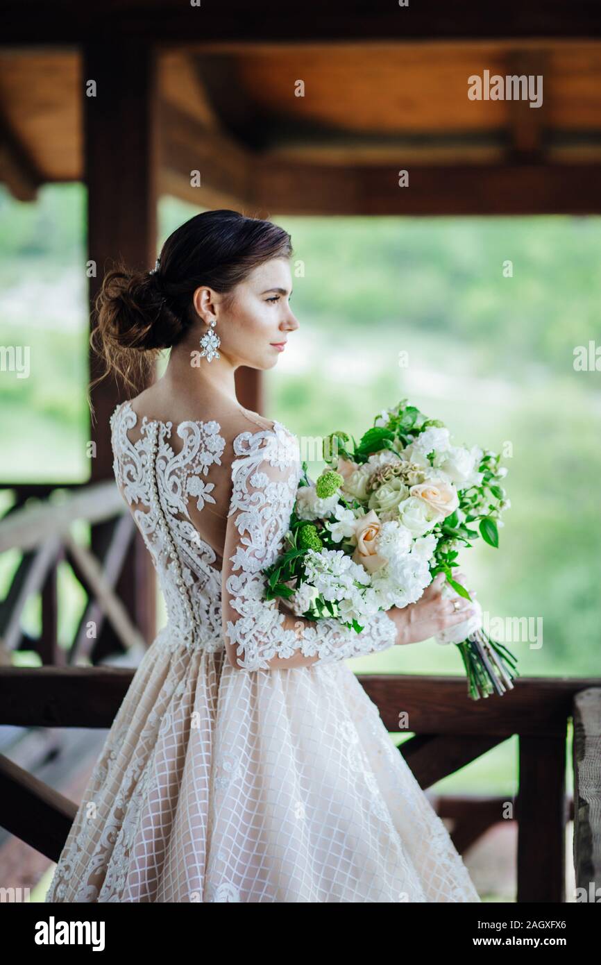 The bride in a magnificent, white, wedding dress with a wedding flowers ...