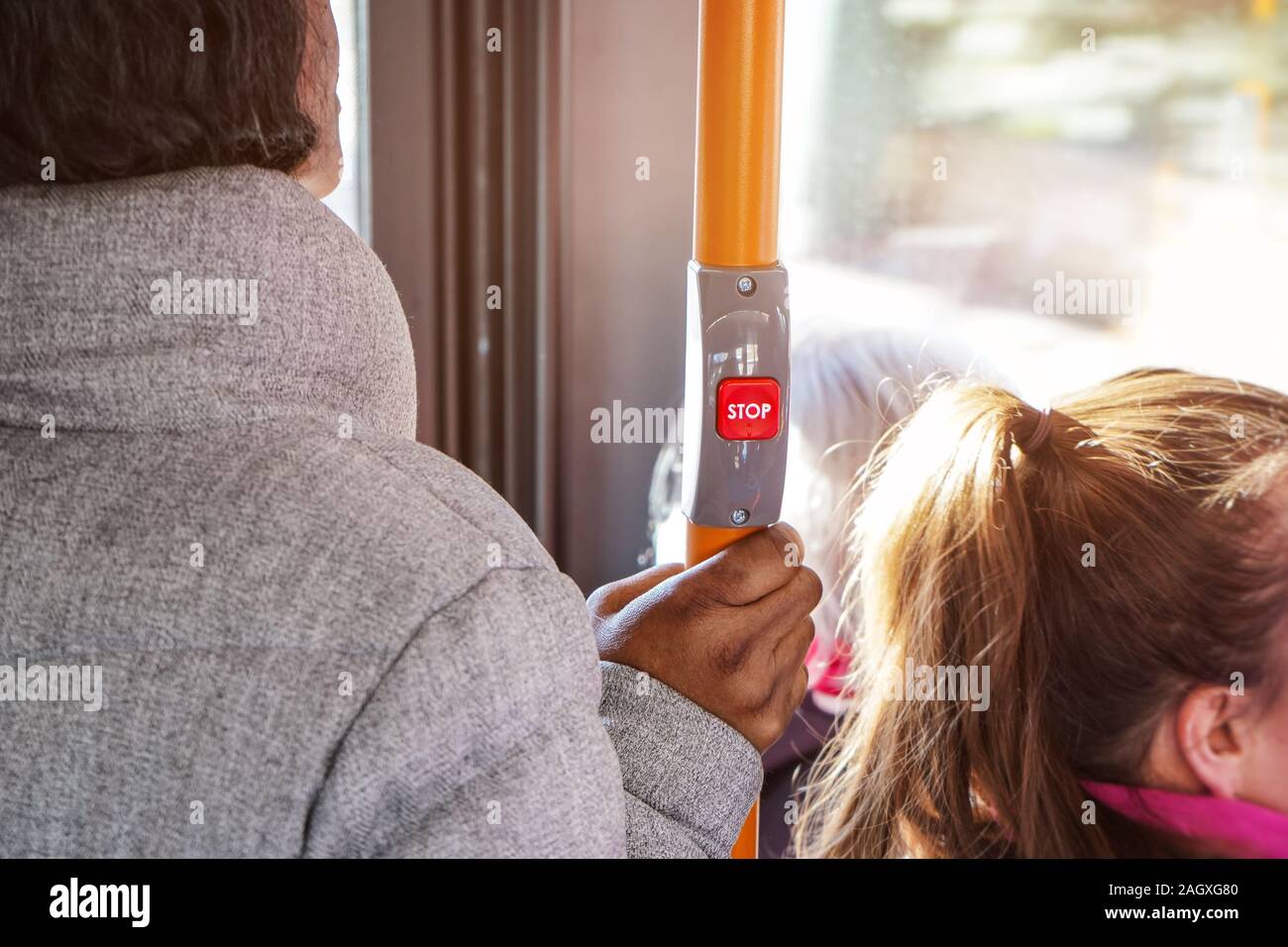 Anonymous woman commuting on public transport bus, detail to her hand ...