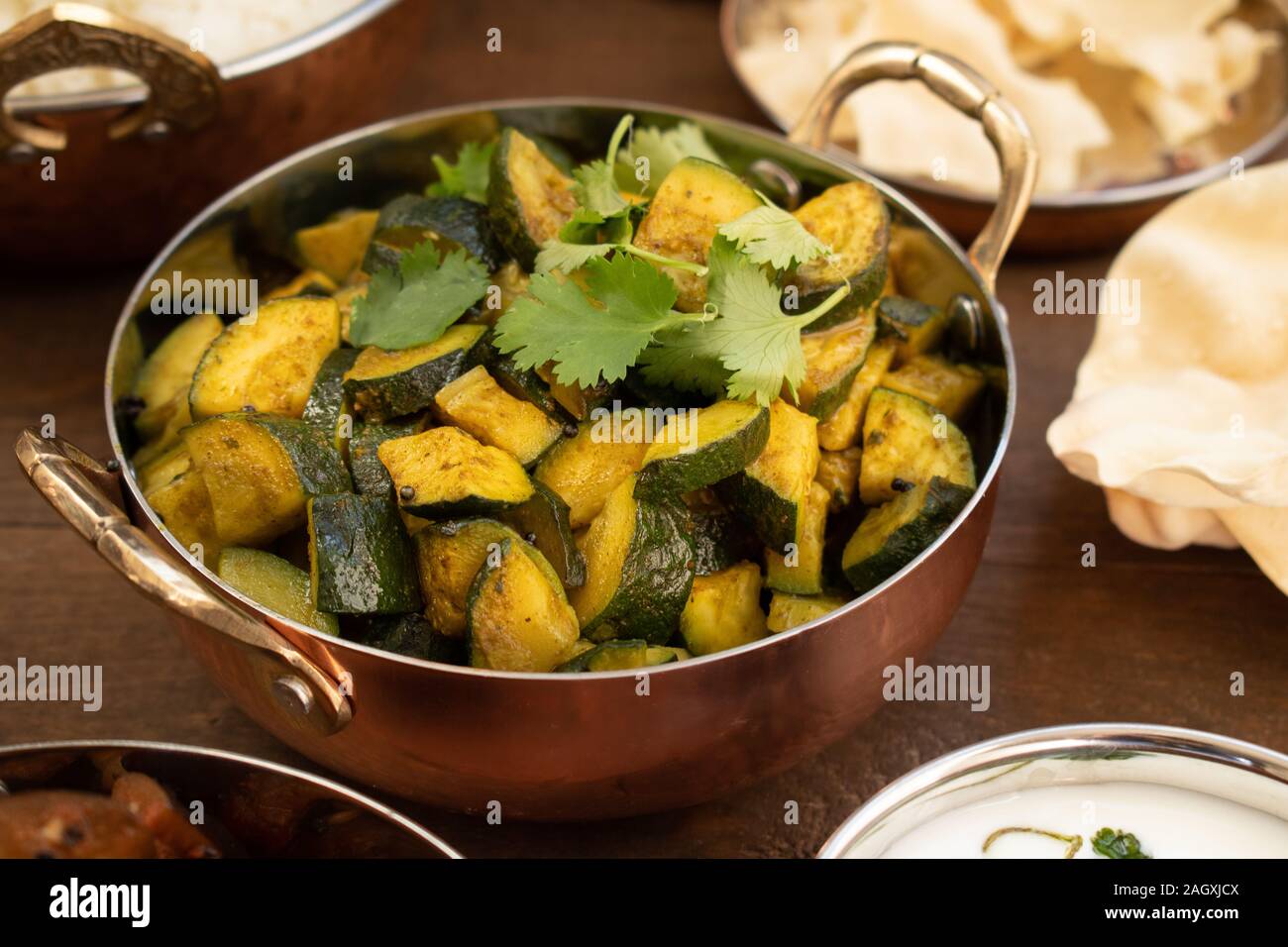 Indian style zucchini curry served in copper bowl Stock Photo - Alamy