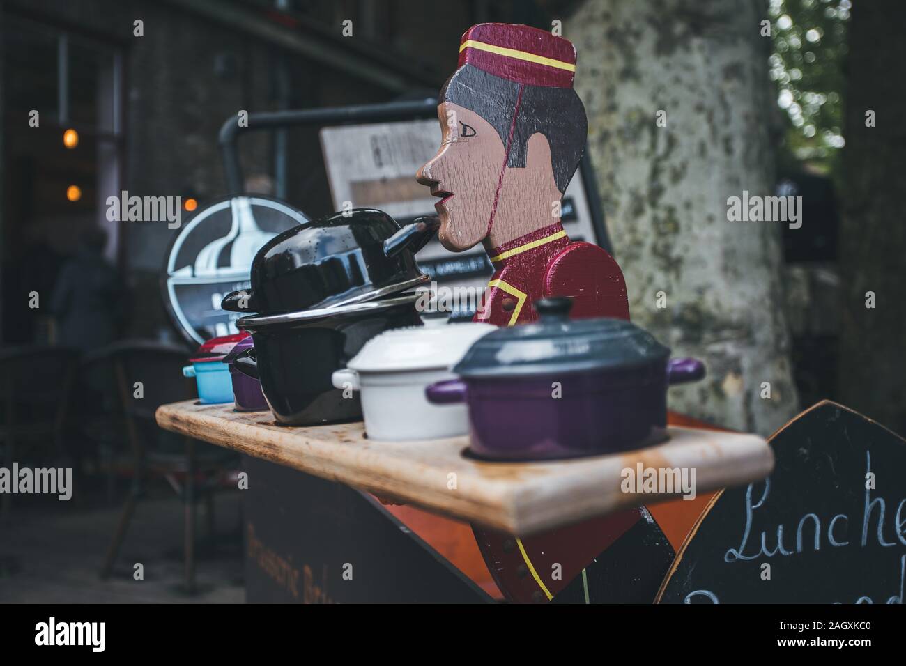 Sign in the form of a waiter with a board on which stand decorative ...