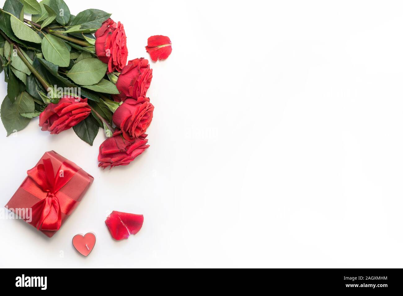 Romantic table setting with bouquet of red roses and gift. Top view ...