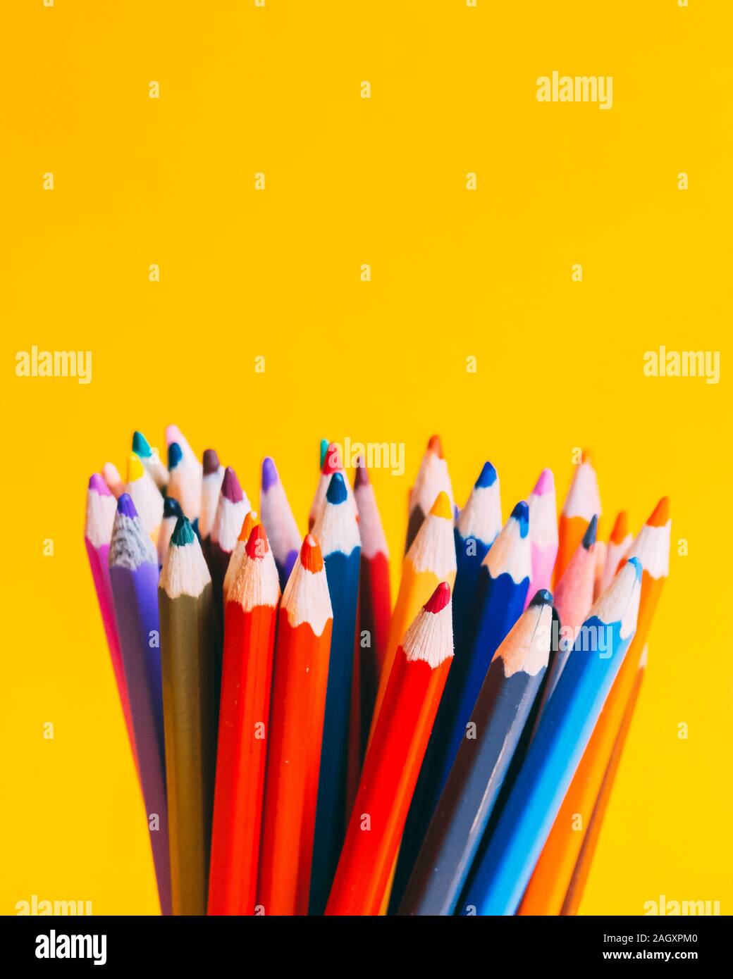 Colored pencils on the pastel yellow background. Crop for instagram ...