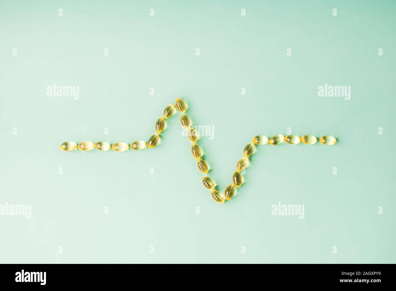 Yellow candy scattered in the shape of a heartbeat on a green ...