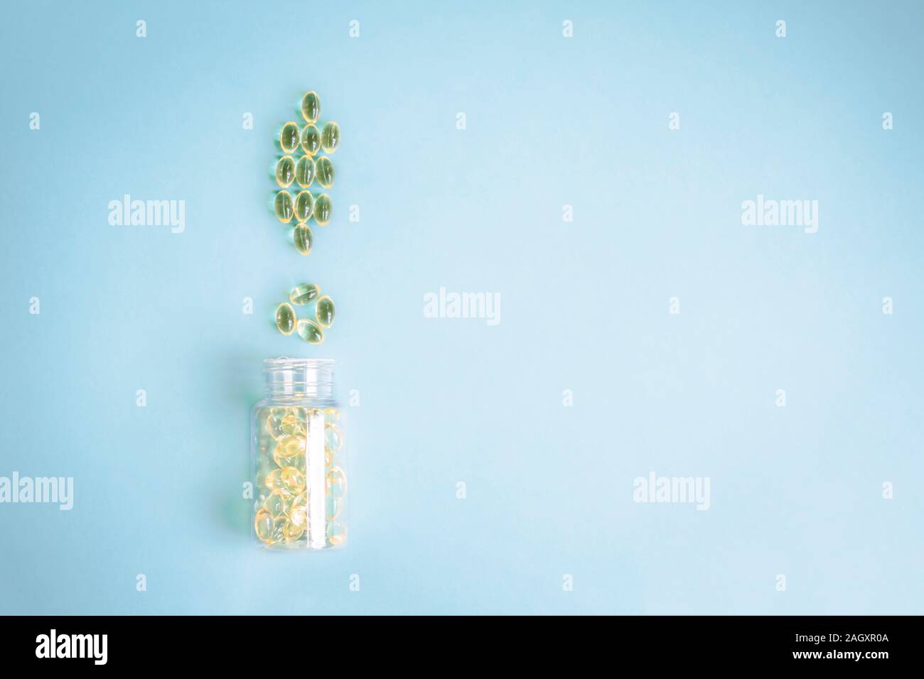 Pills yellow laid out in the form of an exclamation point on the blue ...