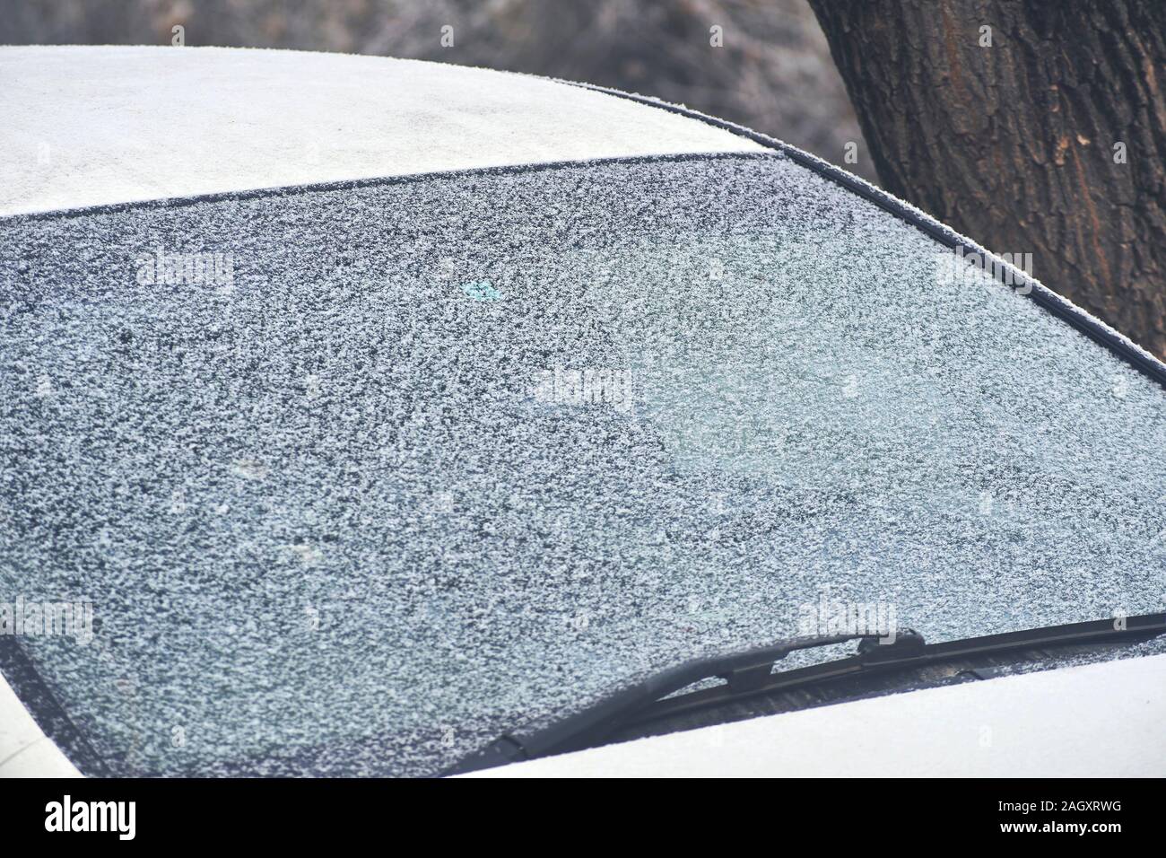Frozen car window. Rear window of the car with a janitor covered with ...