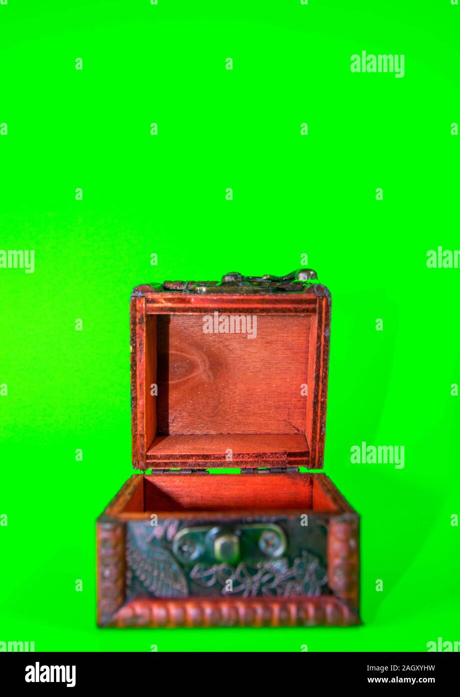A small toy wooden chest, taken against a bright green screen ...