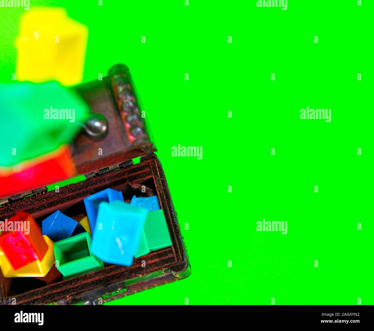 A wooden chest full of plastic houses, taken against a green screen ...