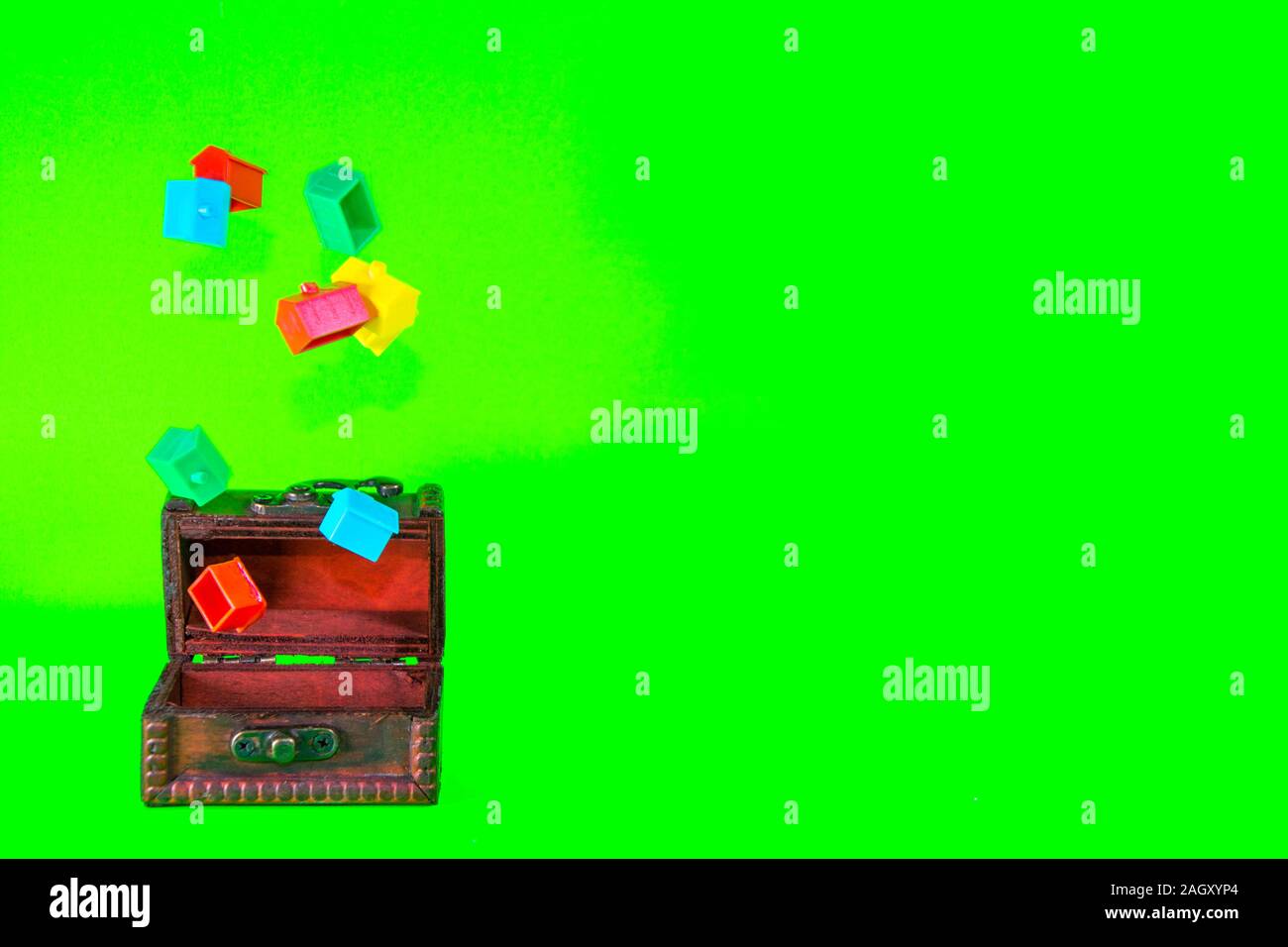 A wooden chest full of plastic houses, taken against a green screen ...