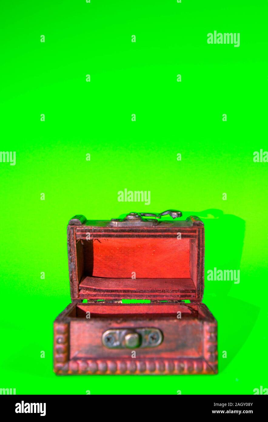 A small toy wooden chest, taken against a bright green screen ...