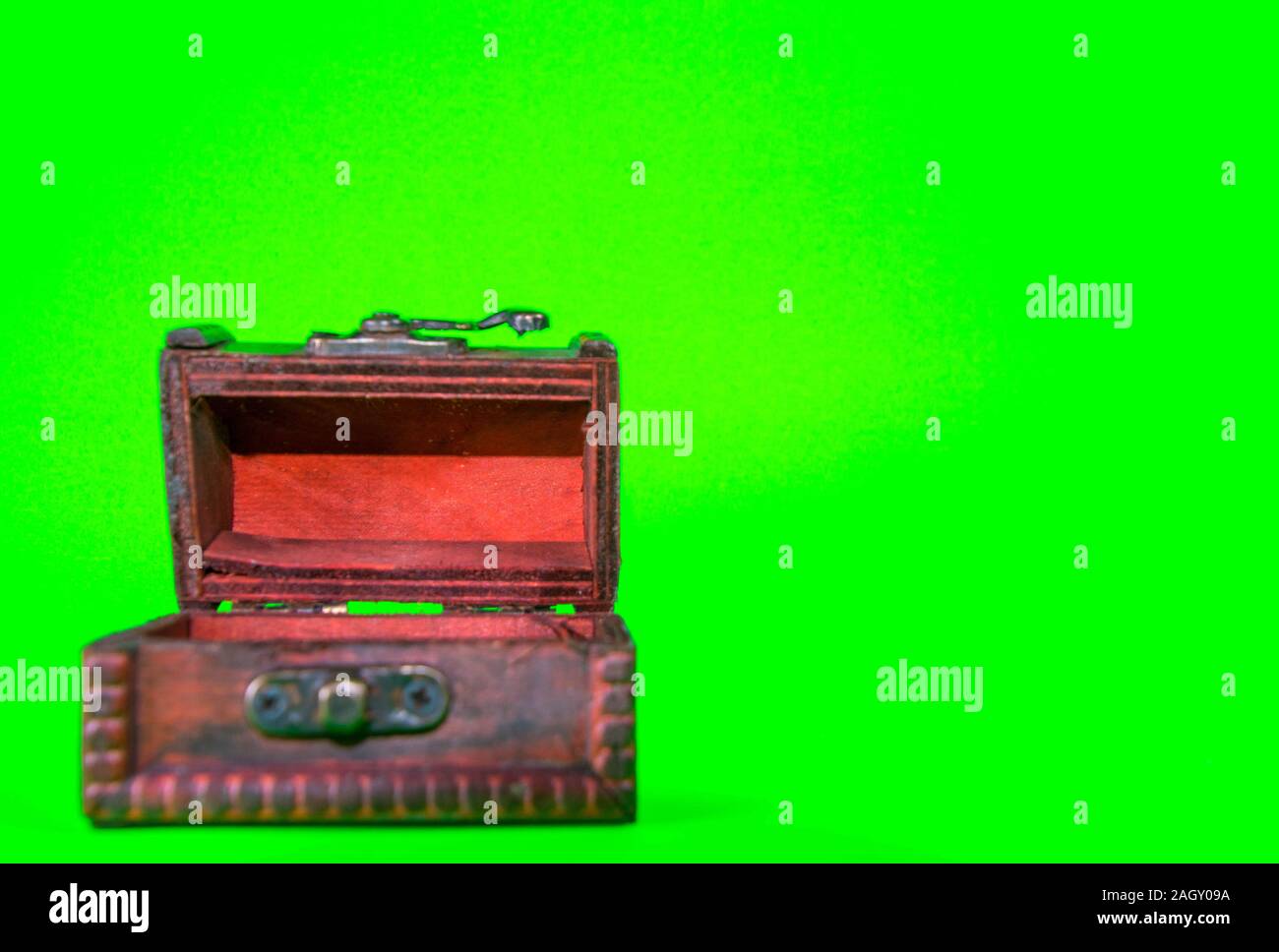 A small toy wooden chest, taken against a bright green screen ...