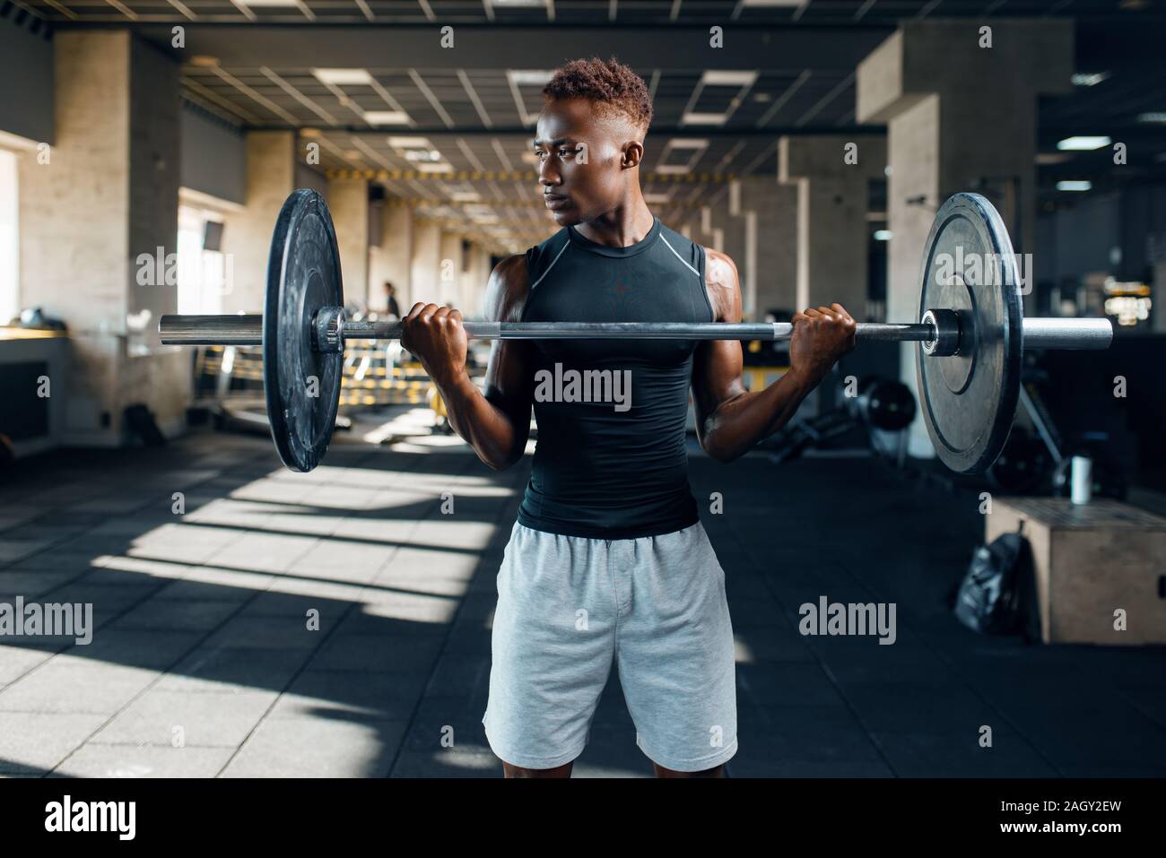 Athlete doing exercise with barbell in gym Stock Photo - Alamy