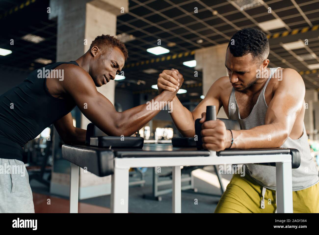 Two men fighting, arm wrestling training in gym Stock Photo - Alamy