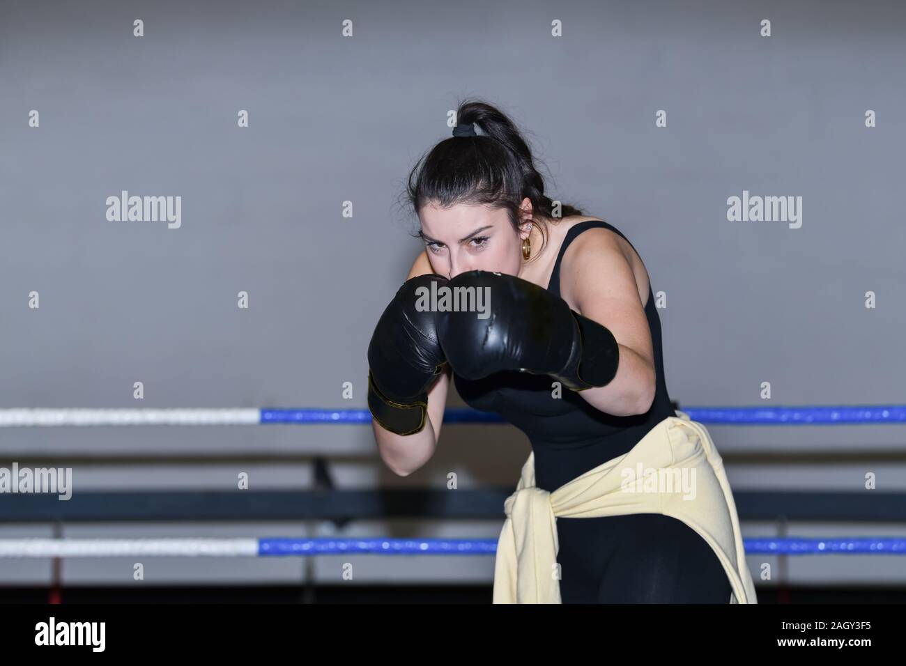 Focused woman in boxing gloves guards herself Stock Photo - Alamy