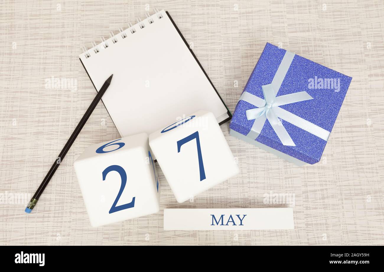 Calendar with trendy blue text and numbers for May 27 and a gift in a ...