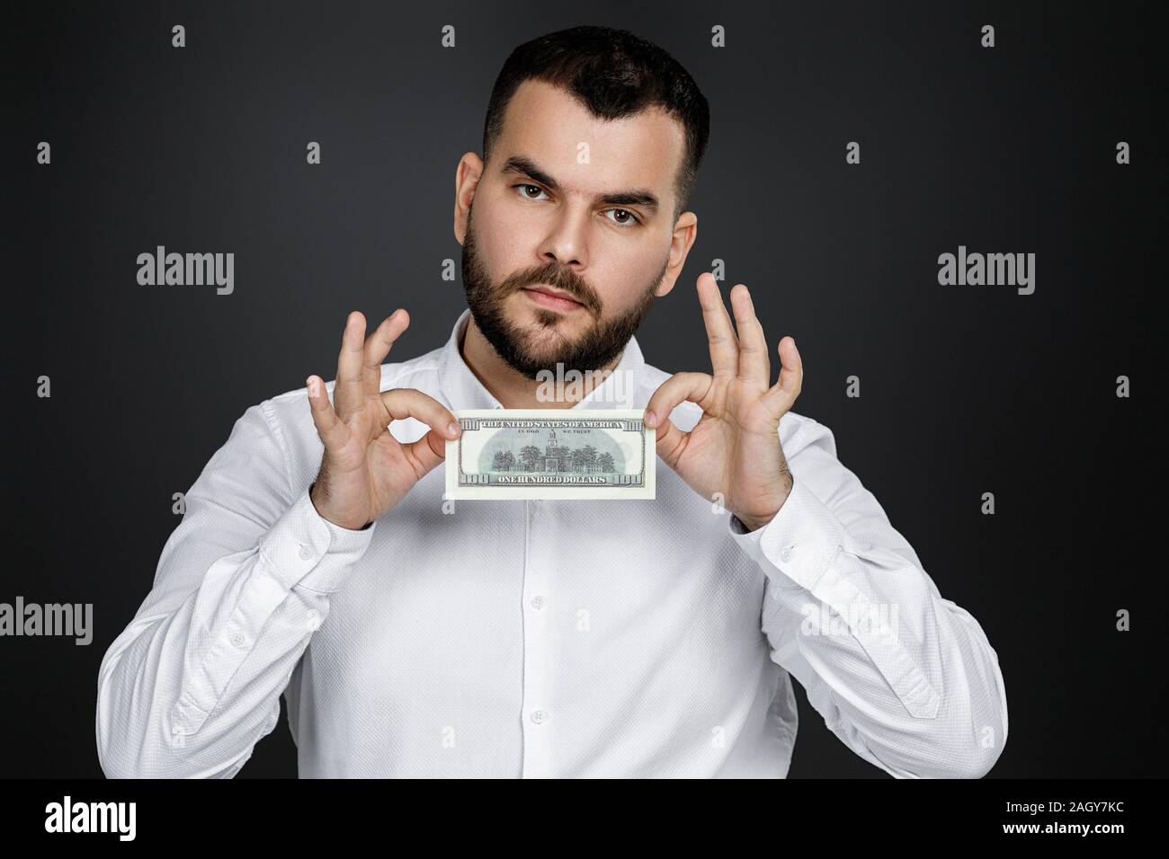 Portrait of young man holding money banknotes isolated on black ...