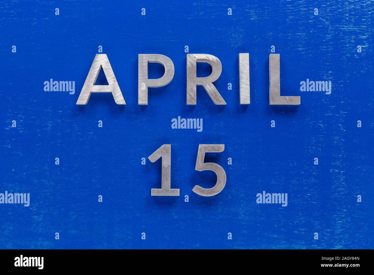 the words april 15 layed on blue painted board with thick silver metal ...