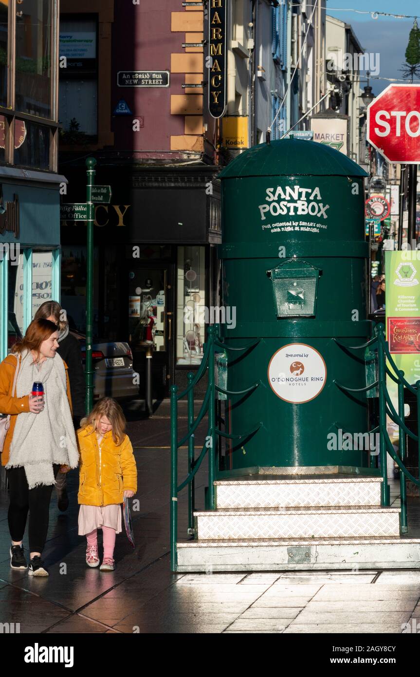 People walking past green Santa Post box or mail box or letter box in ...